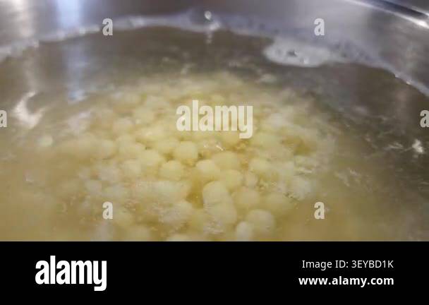 Cooking process of small round pasta boiling in a stainless steel pot ...