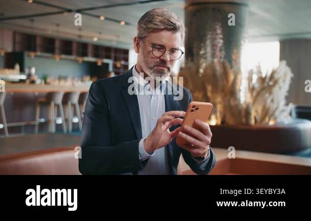 Shot of handsome smiling man in formal outfit using smartphone in ...