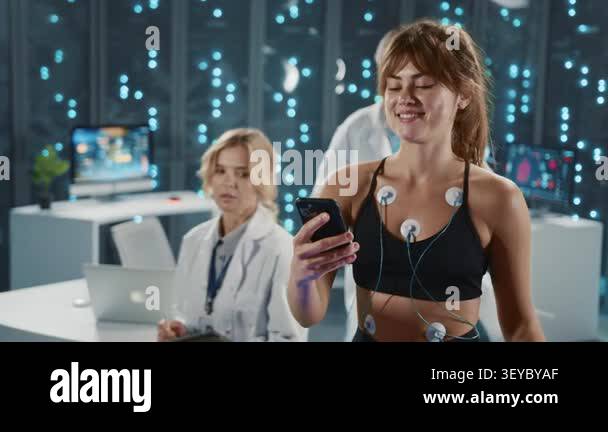 Young athletic woman walking treadmill using phone application. Data ...