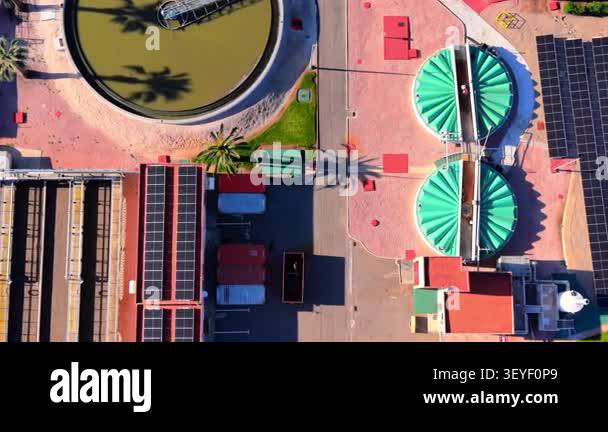 Wastewater treatment plant with solar panels, Spain. Circular clarifier ...