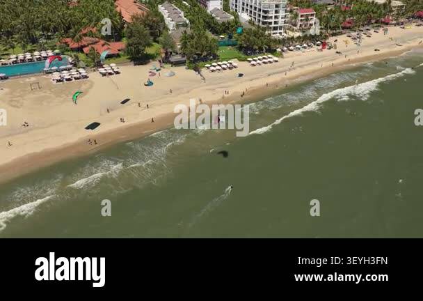 Aerial shot of surfers riding waves near the coastline Stock Video ...