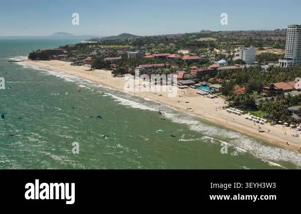 Aerial shot of surfers riding waves with colorful kites Stock Video ...