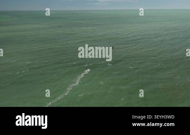 Aerial shot of surfers riding waves with colorful kites Stock Video ...