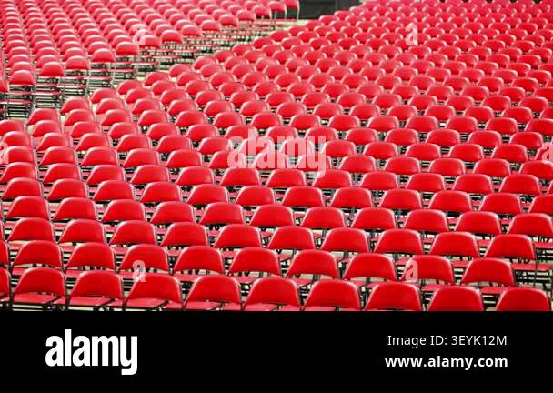 Rows of empty red chairs prepared for a large event, ceremony ...