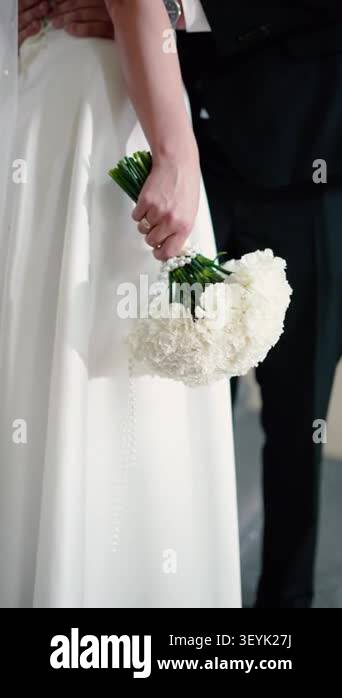 A bride with a wedding ring on her hand strokes and admires her wedding ...