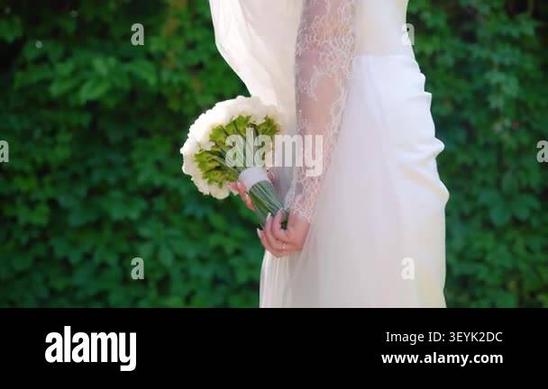 A bride with a wedding ring on her hand strokes and admires her wedding ...