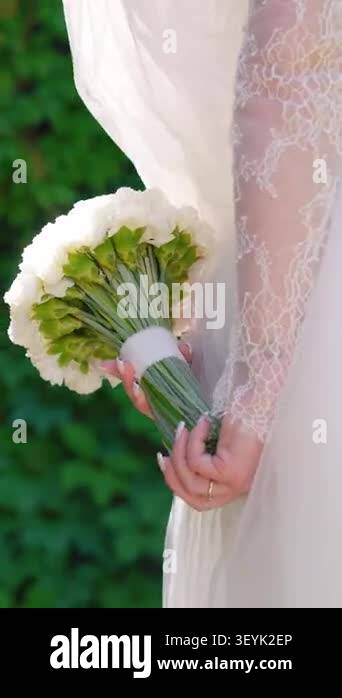 A bride with a wedding ring on her hand strokes and admires her wedding ...