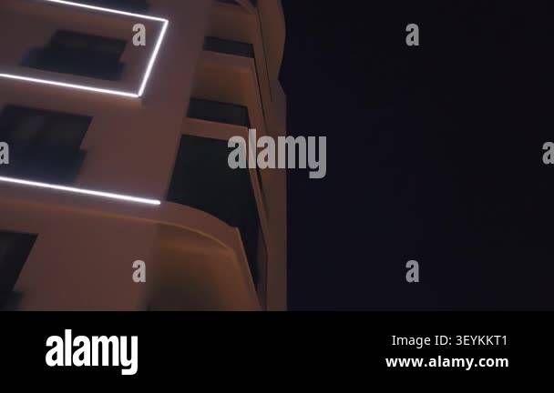 Drone close up of a modern building facade with glowing LED lines ...