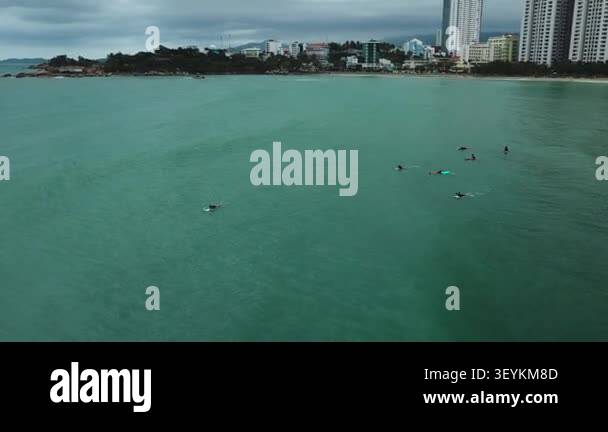 Aerial shot of small waves forming with surfers waiting in Vietnam sea ...