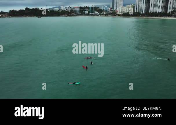 Aerial shot of surfers floating in blue green ocean water in Vietnam ...