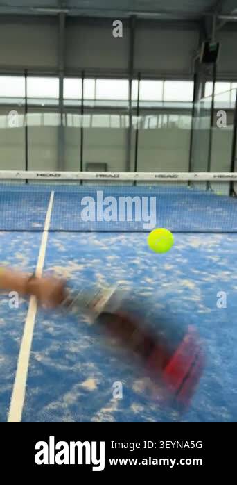 Rolling padel tennis ball on blue court surface near net, close up ...