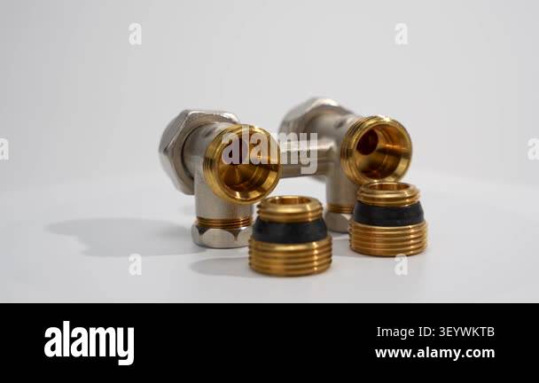 A heating valve assembly and brass adapters rotate against a white ...