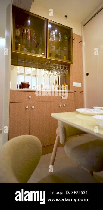 A contemporary wooden bar cabinet with glass display shelves and ...