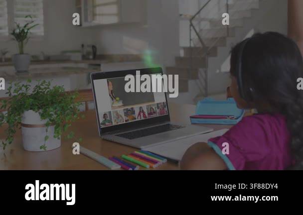 Child watching laptop and lifting arm at table as teacher leading green ...