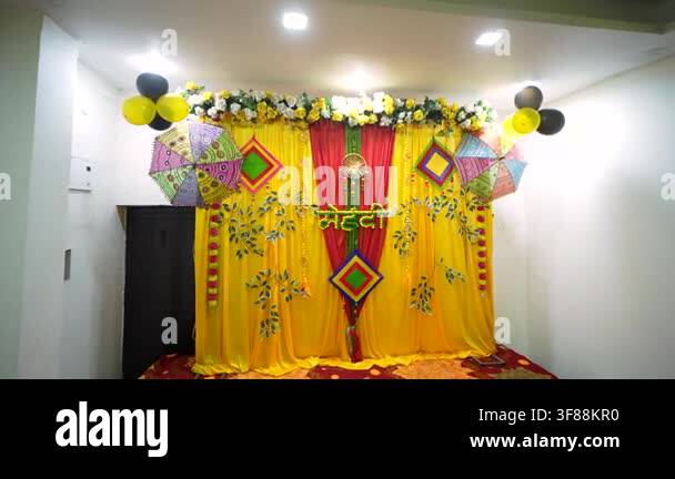 A colorful stage backdrop decorated with yellow fabric, flowers, and ...
