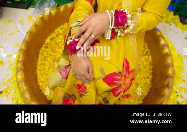 A person in yellow clothing wears decorative floral bracelets during a ...