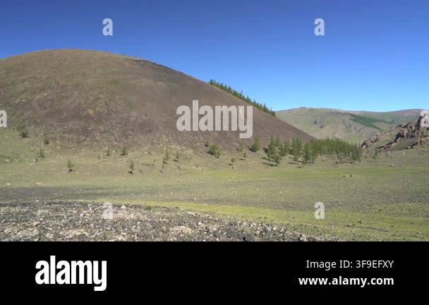 Basalt volcanic hill rises above rugged terrain, revealing tuff and ...
