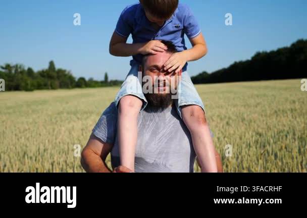 Little kid sitting on shoulders of his daddy against background of ...