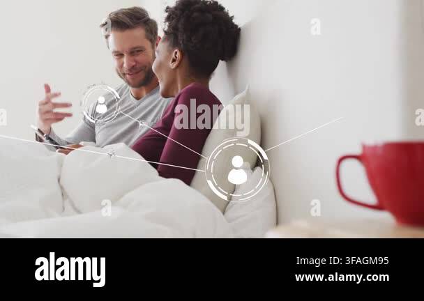 Man showing smartphone content, woman leaning in, network icons ...