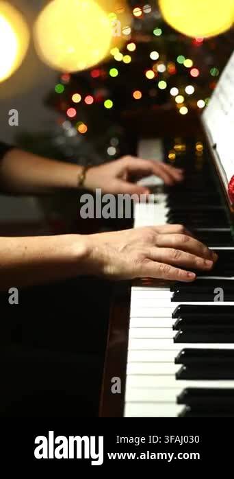 Closeup of two hands playing piano keys, festive background with ...