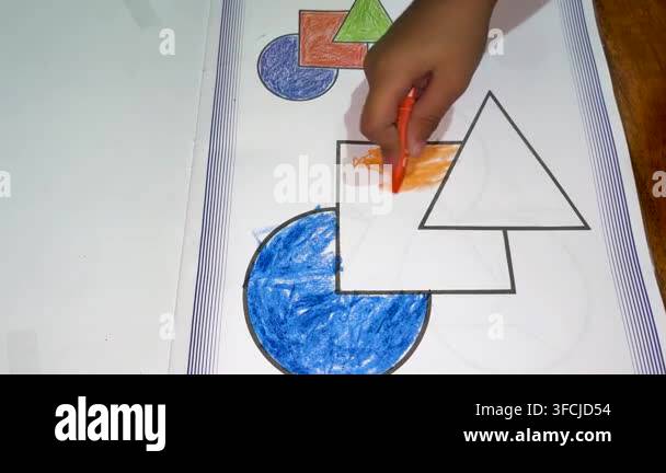 Young Child Coloring Geometric Shapes With Orange Crayon During ...