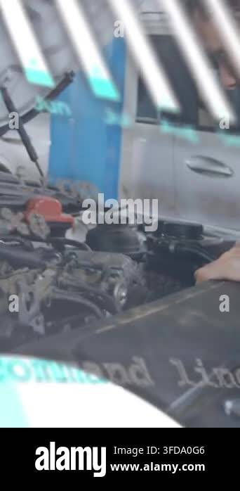 Vertical video: Mechanic checking engine with propped hood for auto ...
