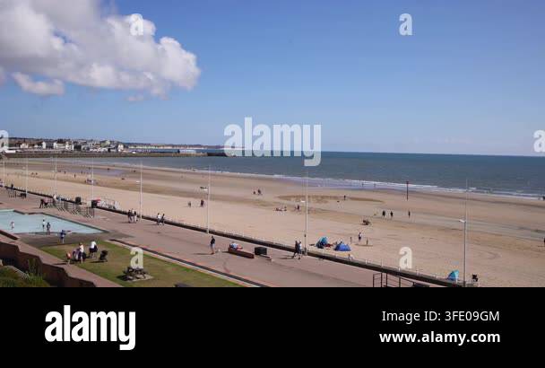 Slow motion footage overlooking the wide sandy beach and seafront at ...