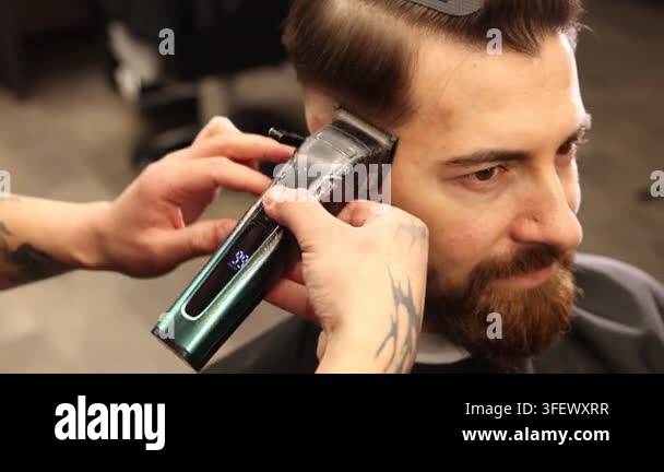 Stylist cutting man's hair with clipper in barbershop, closeup Stock ...