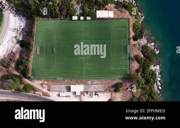 Aerial top down view of green soccer football field by the sea coast in ...