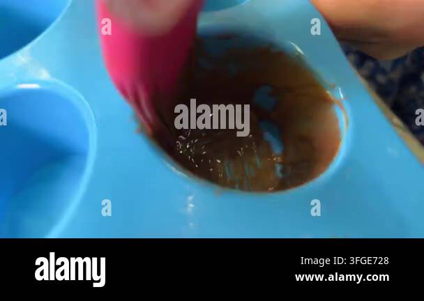 Close Up Of Silicone Brush Spreading Melted Chocolate Inside A Mold