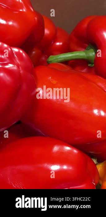 Bright red bell peppers fill a large cardboard display box, showcasing ...