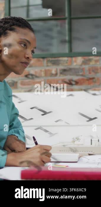 Vertical video: Designer leaning and writing with pen in pad, pausing ...
