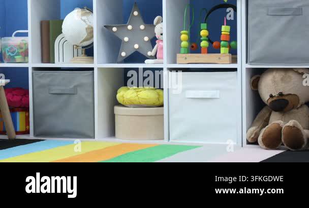 Shelving unit with different toys and decor near blue wall in child's ...