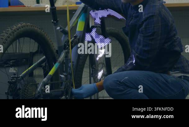 Kneeling bike tech pulling yellow tape, measuring frame fit while ...