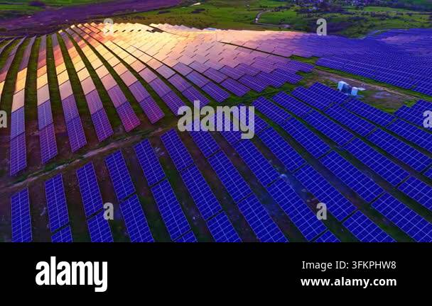 Evening light gradients color solar panel rows. Aerial shot shows ...