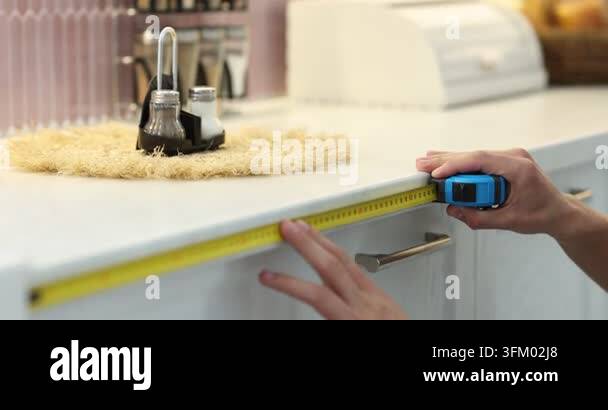 Man measuring countertop with tape indoors, closeup. Camera moving in ...
