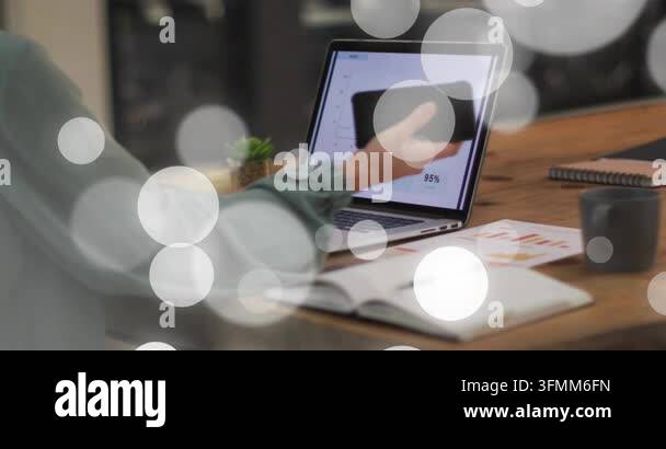 Woman reaching smartphone, dictating charts, typing laptop business ...