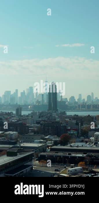 Vertical video: Landing footage of industrial site in town. Hazy ...
