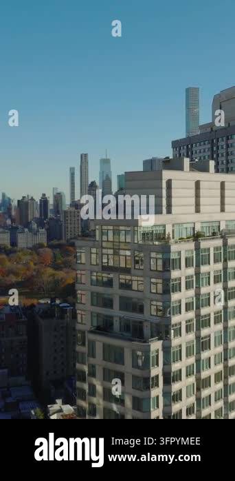 Vertical video: Elevated fly around high rise buildings. Revealing ...