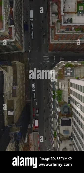 Vertical video: Top down panning shot of high rise buildings along ...