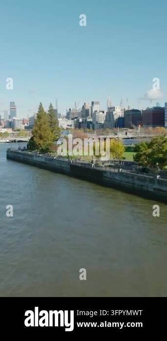 Vertical video: Forwards fly above Hudson river and Rockefeller Park ...