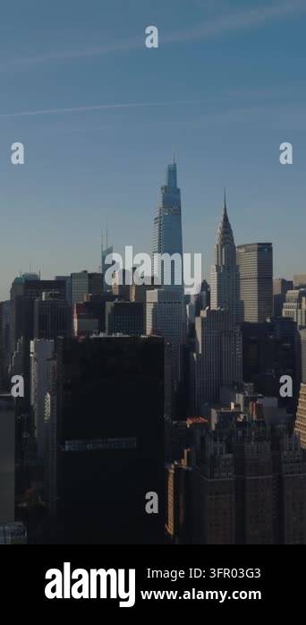 Vertical video: Forwards fly above high rise buildings in midtown ...
