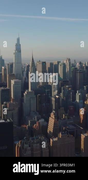 Vertical video: Backwards fly above city. Aerial panoramic view of high ...