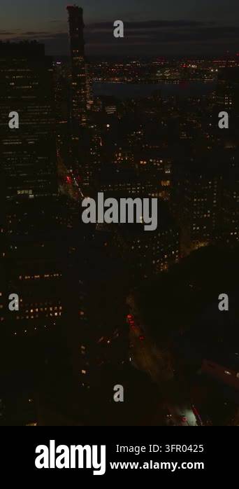 Vertical video: Fly above night city. High rise buildings in Civic ...