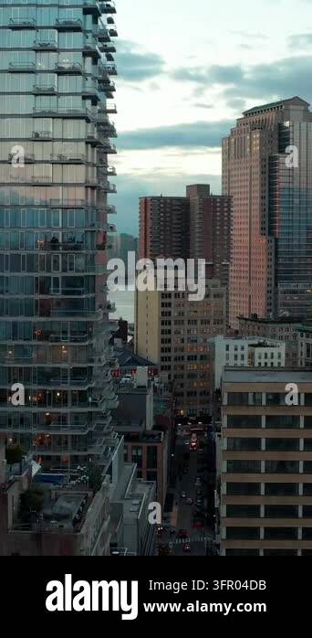 Vertical video: Descending aerial footage of high rise buildings in ...