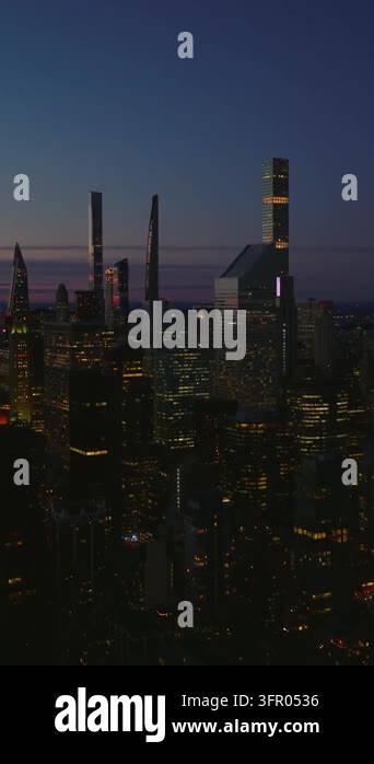 Vertical video: Rising footage of night city. Illuminated high rise ...