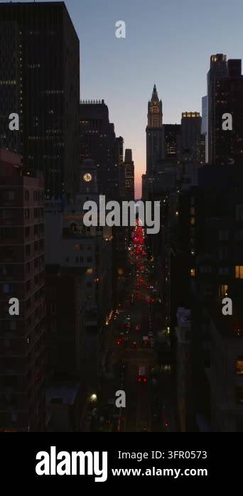 Vertical video: Forwards fly above city. Silhouettes of high rise ...