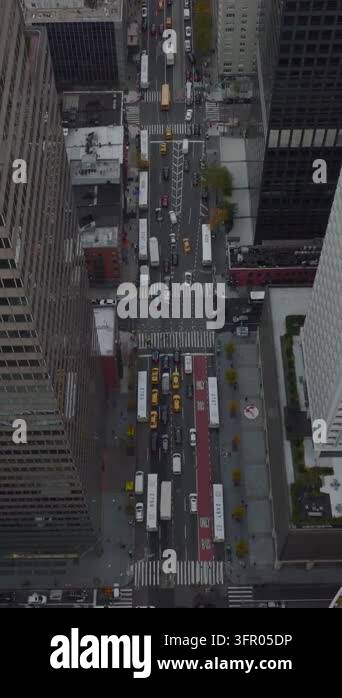 Vertical video: High angle ascending footage streets between high rise ...