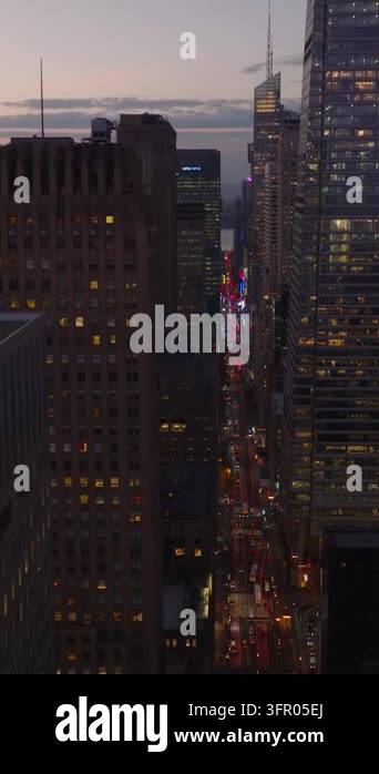 Vertical video: Forwards fly high above busy street between modern high ...