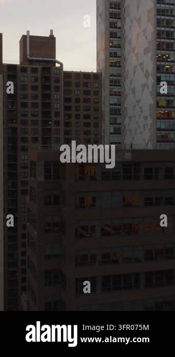 Vertical video: Forwards fly between high rise apartment buildings in ...
